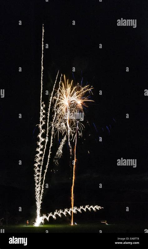 Man Launching Fireworks At A Village Firework Display With One Rocket Going Dangerously