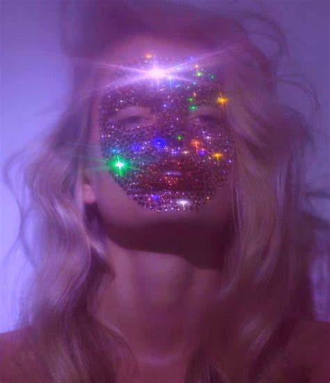 A Woman S Face Is Covered With Colorful Lights And Sparkles As She Poses For The Camera