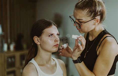 A Young Makeup Artist Applies A Medicinal Liquid Under A Girl S Eyes