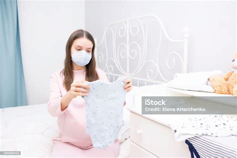 보호 의료 마스크를 착용 한 임산부는 신생아를위한 물건을 봅니다 아이의 기대 모성 가족에 대한 스톡 사진 및 기타 이미지 가족 만짐 보살핌 Istock