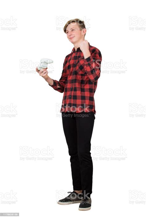 콘솔을 들고 주먹을 들고 성공을 축하하는 흰색 배경 위에 고립 된 비디오 게임을하는 즐거운 십대 소년 흥분 사춘기 우승자 전체 길이 가상 세계에서 재미를 게이머에 대한 스톡