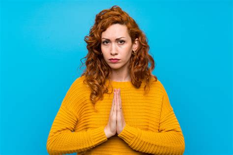 노란색 스웨터와 빨간 머리 여자는 함께 손바닥을 유지합니다 무언가를 요구하는 사람 노랑에 대한 스톡 사진 및 기타 이미지