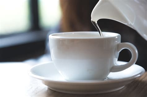 주전자를 들고와 나무 테이블에 흰색 컵에 차를 붓는 사람의 근접 촬영 이미지 갈색에 대한 스톡 사진 및 기타 이미지 갈색