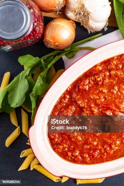 빨간색 세라믹 냄비와 원시 펜 네 후추의 열매 마늘 양파 로켓 샐러드에 홈메이드 느린 밥 솥 Bolognese 소스 고기에 대한 스톡 사진 및 기타 이미지 Istock