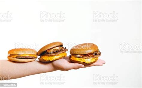 흰색 배경에 손에 햄버거 3 개의 아름 다운 햄버거 손에 거짓말 0명에 대한 스톡 사진 및 기타 이미지 0명 건강하지 못한 생활방식 건강한 생활방식 Istock