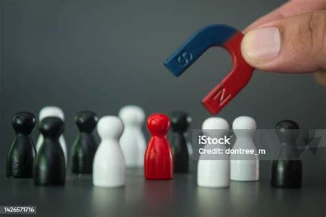 남자 손은 자석을 들고 군중 블록에서 빨간 남자 나무 인물을 당깁니다 비즈니스 인적 자원 관리 유독 한 사람 및 리더십 개념 개성 개념에 대한 스톡 사진 및 기타 이미지