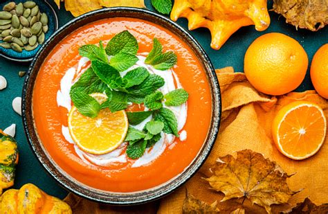 크림 오렌지 민트를 곁들인 달콤한 호박 수프 퓌레 겨울이나 가을에 건강한 채식 편안한 느린 음식 녹색 파란색 테이블 배경에 수프 그릇입니다 상위 뷰 감귤에 대한 스톡 사진