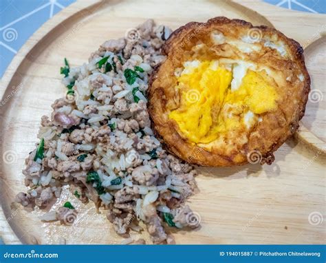 Basil Leaves Cooked With Minced Pork With Over Hard Fried Egg On Wooden
