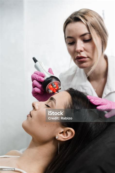 젊은 여성 클로즈업을 위한 빨간불로 무선 주파수 리프팅 피부과 전문의는 무선 주파수 Rf 피부 타이트닝을 하고 있습니다 Rf 안면거상술은 처진 피부를 탄력 있게 하고 들어