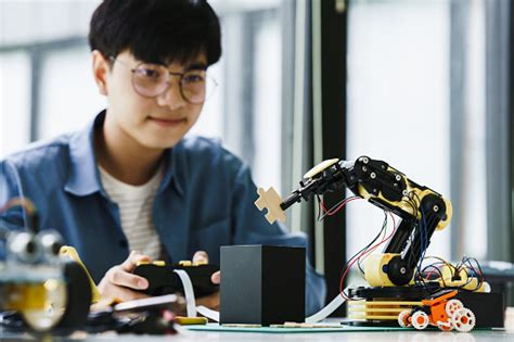 아시아 십대 학생들은 집에서 로봇 팔과 로봇 자동차 숙제 프로젝트를 하거나 놀고 회로를 조립하고 코딩합니다 로봇 공학 프로그래밍