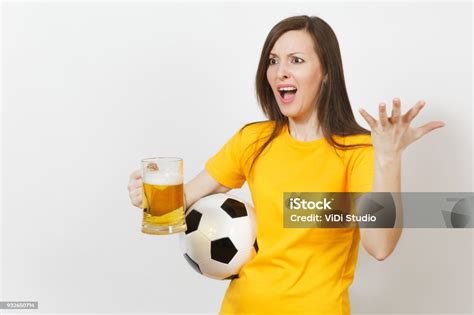 꽤 유럽 젊은 슬픈 화가 여자 축구 팬 또는 노란색 유니폼 선수 맥주의 파인트 찻잔을 보유 하 고 흰색 배경에 고립 된 팀에 대 한 걱정 스포츠 축구 라이프 스타일 개념