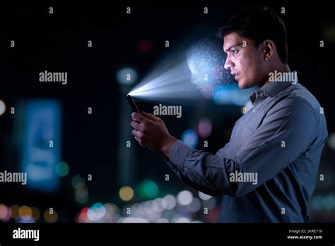 Young Man Using Facial Recognition Technology With Mobile Phone Stock