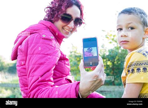 Mother And Son Using Technology Mobile Cell Phone To Take Their Own