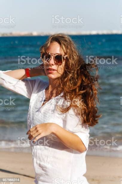 파도와 푸른 바다 하늘에는 화창한 날 라이프 스타일 포즈와 미소 바람에 구름의 배경에서 긴 머리를 가진 아름 다운 젊은 갈색 머리 여자의 클로 우즈 업 초상화 건강한 생활