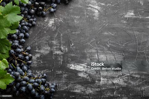 빈티지 어두운 콘크리트 배경에 검은 육즙 포도 포도로 만든 프레임 검은 색 으로 긁힌 배경에 텍스트 또는 메뉴공간을 복사합니다 어두운 배경에 텍스트를위한 장소와 포도 과일로