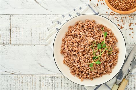 오래된 흰색 나무 배경에 파슬리 잎과 버터와 그릇에 메밀 죽 수제 음식 건강한 식단을 위한 글루텐 프리 고대 곡물 맨 위 보기입니다 공간을 복사합니다 가득 찬에 대한 스톡