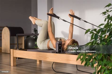 개혁자 침대에서 필라테스를 훈련하는 여성 체육관에서 피트니스 운동을 위한 리포머 필라테스 스튜디오 머신 적합 하 고 건강 하 고 강한 진정한 몸매 피트니스 개념 필라테스에