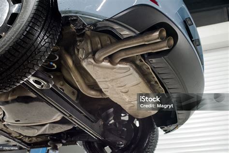 현대 자동차는 기술자가 아래에서 유지 보수 작업을 수행하는 동안 자동차 수리점의 유압 플랫폼에서 차대 배기 시스템 및 리어 서스펜션을 보여줍니다 배기관에 대한 스톡 사진 및