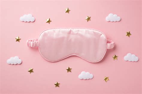 카피 스페이스와 고립 된 파스텔 핑크 배경에 핑크 실크 수면 마스크 구름과 황금 별의 상단 보기 사진 잠자기에 대한 스톡 사진