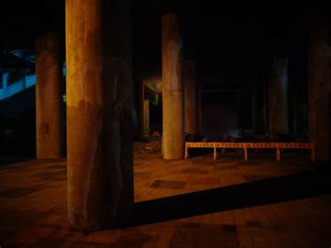 짙은 밤 풍경 속 기둥과 벽면에 살아 꿈틀대는 인간들