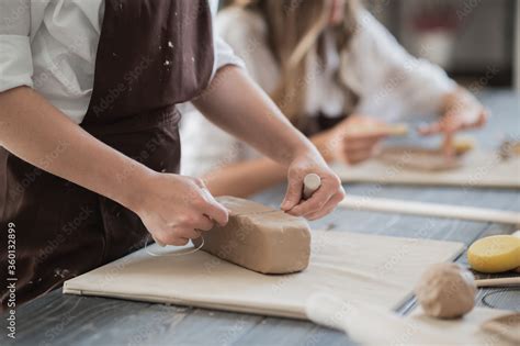 Female Potter Cutting Piece Of Pottery Clay Using Trimming Tool Close