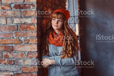 그녀의 팔과 함께 따뜻한 스웨터와 모자를 입고 외로운 빨간 머리 소녀 벽돌 벽에 기대어 아파트에 대한 스톡 사진 및 기타 이미지 아파트 여자 12월 Istock