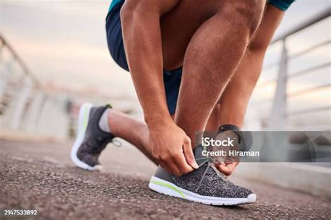 근접 촬영 남자와 넥타이 신발 끈 피트니스 야외 활동 및 운동과 웰빙 및 훈련 사람 러너나 애슬리트가 런닝 슈즈를 신고 햇볕을 쬐며 운동해 자연과 함께 건강하게 휴식 스포츠