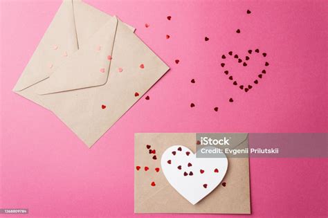 발렌타인 데이에 대한 낭만적 인 사랑 편지의 개념 하트로 뒤덮인 분홍색 배경에 흰색과 빨간색 하트가 있는 크래프트 페이퍼로 만든