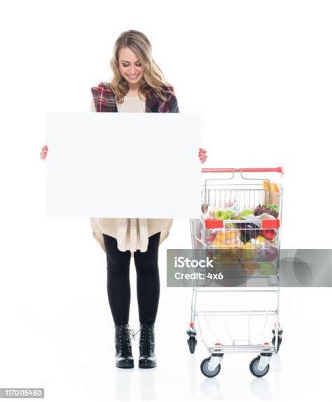 쇼핑 카트 옆에 서있는 아름다운 여성 하나의 플래카드를 들고 아래를 봄에 대한 스톡 사진 및 기타 이미지 아래를 봄 여자