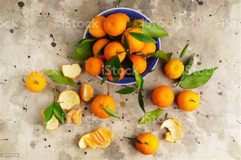 귤 회색 파란색 접시에 잎 배경 시멘트 유기농 채식 음식입니다 겨울 지역 과일입니다 건강 한 해독을 먹는 개념 감귤에 대한 스톡