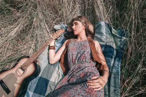 Premium Photo Hippie Woman With Guitar Lying On Grass