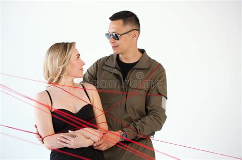 A Young Couple A Man And A Woman Are Wrapped In Red Threads