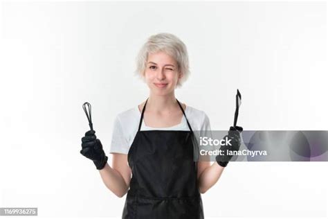 흰색 티와 검은 앞치마에 꽤 젊은 헤어 스타일리스트는 흰색 배경 위에 고립 된 컬러 믹서와 페인트 브러시를 들고 검은색에 대한