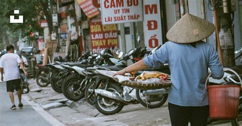 갈색 모자와 흰 셔츠를 입은 남자가 낮에 오토바이를 타고 있다 사진 Unsplash의 무료 베트남 이미지