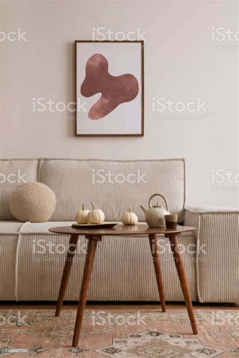모의 포스터 프레임 베이지 색 소파 나무 커피 테이블 둥근 베개 무늬가있는 카펫 조각 및 개인 액세서리가있는 거실 인테리어의 창의적인 구성 가정 장식 템플렛 0명에 대한