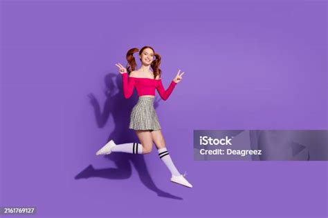 전체 길이 사진 반짝 반짝 매력적인 아가씨 옷을 입고 어깨 최고 점프 높은 Showint V 표지판 빈 공간 절연 보라색 배경 광고에 대한 스톡 사진 및 기타 이미지