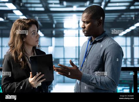 Computer Scientists In Data Center Using Tablet Analyzing Metrics