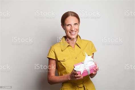 하얀 부드러운 리본과 흰색 바탕에 활을 얹은 분홍색 선물 상자를 들고 행복한 웃음 성숙한 여자 놀라움에 대한 스톡 사진 및 기타 이미지 Istock