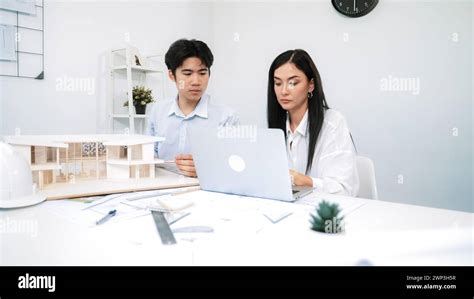 Professional Male Engineer Measure House Model By Using Ruler While Beautiful Cooperative