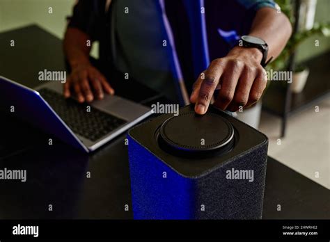 Close Up Of Man Operating Smart Speaker With Home Ai While Working With