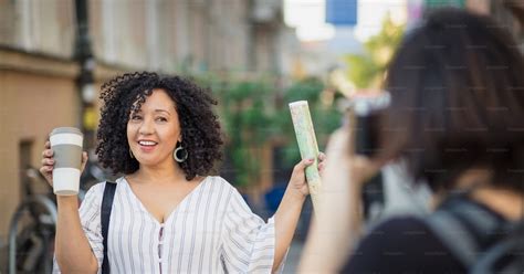 커피 한 잔과 함께 거리에 서 있는 웃는 여자 친구의 사진을 찍는 여자 초점은 배경에 있습니다 사진 Unsplash의 아프리카 계 미국인 여성 이미지