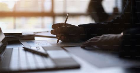 사업가가 사무실 책상에서 서류에 펜을 쓰고 있는 모습을 클로즈업합니다 사진 Unsplash의 기술 이미지