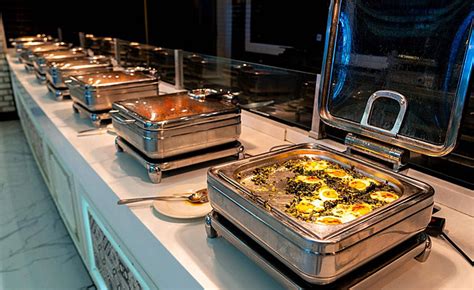 Heated Trays Of A Breakfast Buffet Featuring Eggs And Spinach At A