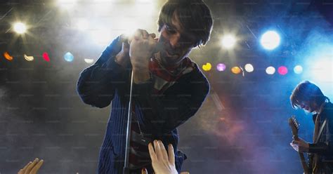 마이크를 들고 무대 위에 서 있는 남자 사진 Unsplash의 음악회 이미지