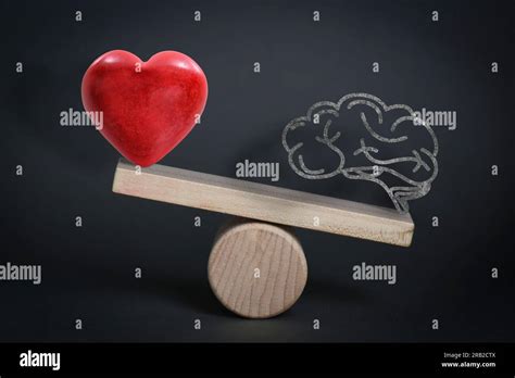 Choosing Between Logic And Emotions Miniature Wooden Seesaw With Heart And Brain Against Black