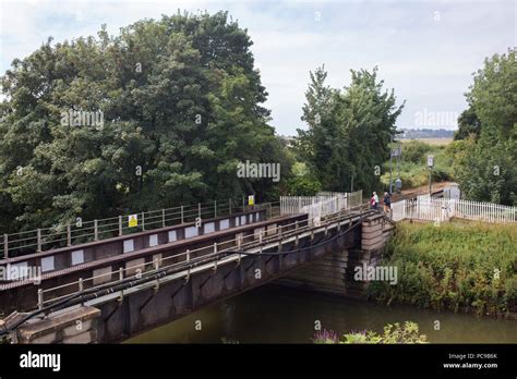 a senior couple walking across an unmanned railway level crossing by a