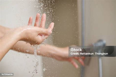 여자는 샤워를하기 전에 온수기에서 수온을 측정하기 위해 손을 사용합니다 가정의 방에 대한 스톡 사진 및 기타 이미지 가정의