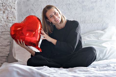 빨간 하트 모양의 풍선을 가진 소녀는 미소 지으며 인생을 즐깁니다 발렌타인 데이를 축하하는 백인 여성 남자 친구에게 보내는 메모 인간의 감정 표정 관계 낭만적 인 휴일의