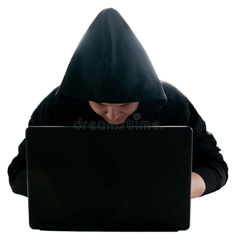 A Hacker In A Black Hoodie And Hood Is Sitting At A Laptop Isolated On