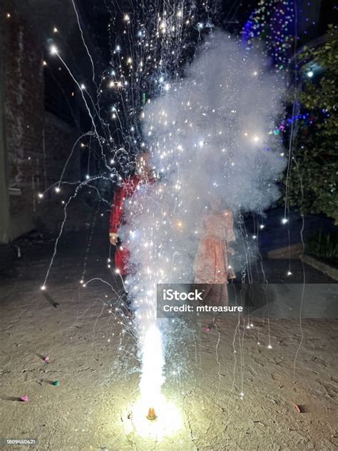 쿠르타 전통 의상을 입은 인도 남성과 살와르 카미즈를 입은 어린 딸이 불이 붙은 불꽃놀이 인도 전통 빛의 축제 디왈리 축하 행사에서 안전하게 서 있는 클로즈업 이미지 2명에